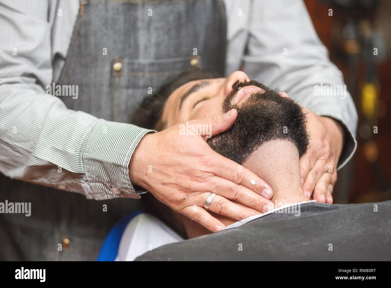 Hair stylist applying after shaving lotion at barber shop Stock Photo ...