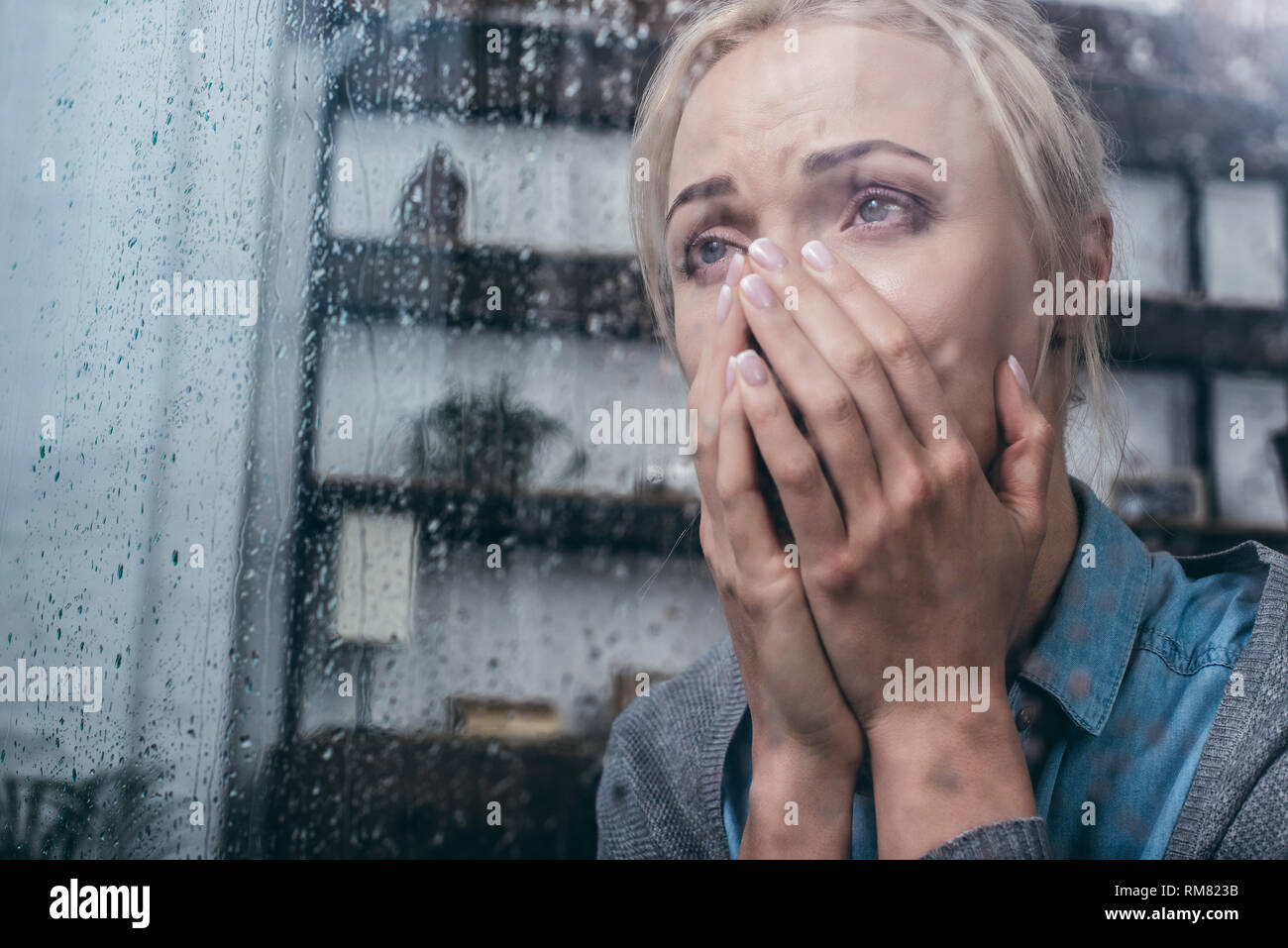 sad adult woman crying and covering face with hands at home through ...