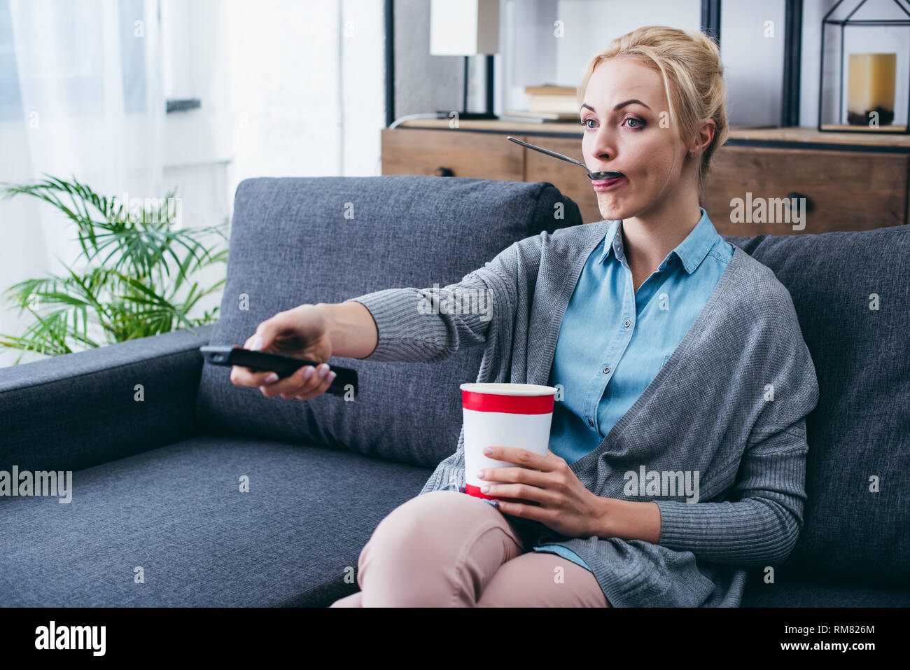 Woman eating ice cream sofa hi-res stock photography and images - Alamy