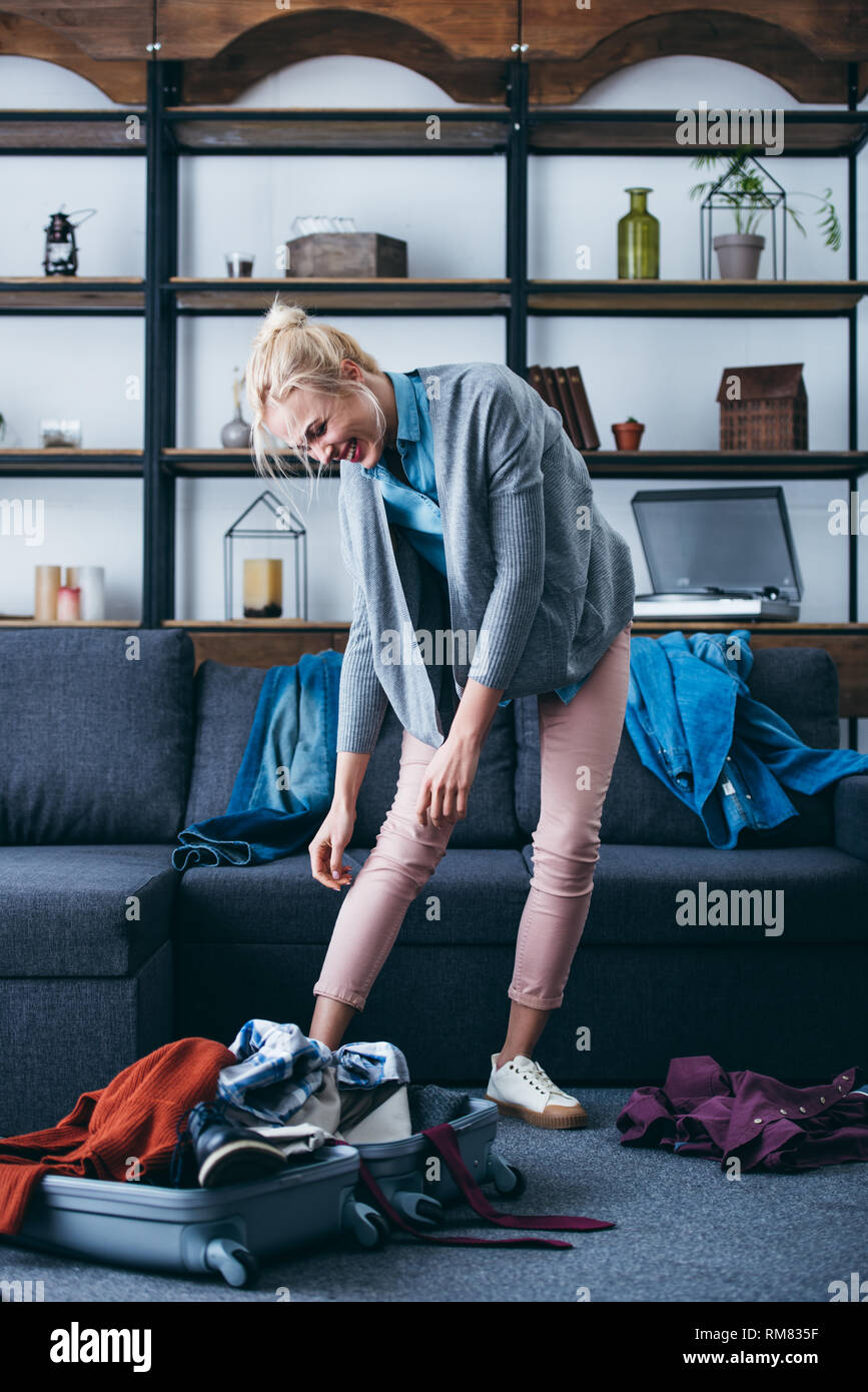 irritated woman packing clothes after breaking up with boyfriend in ...