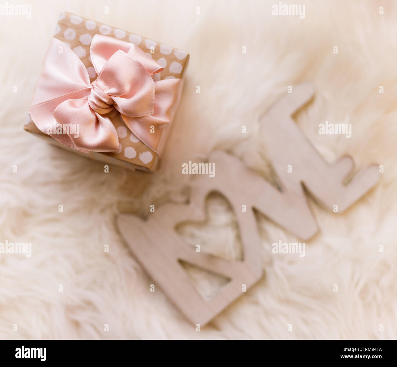 gift box with rose bow-knot and wooden letters love on fluffy ...