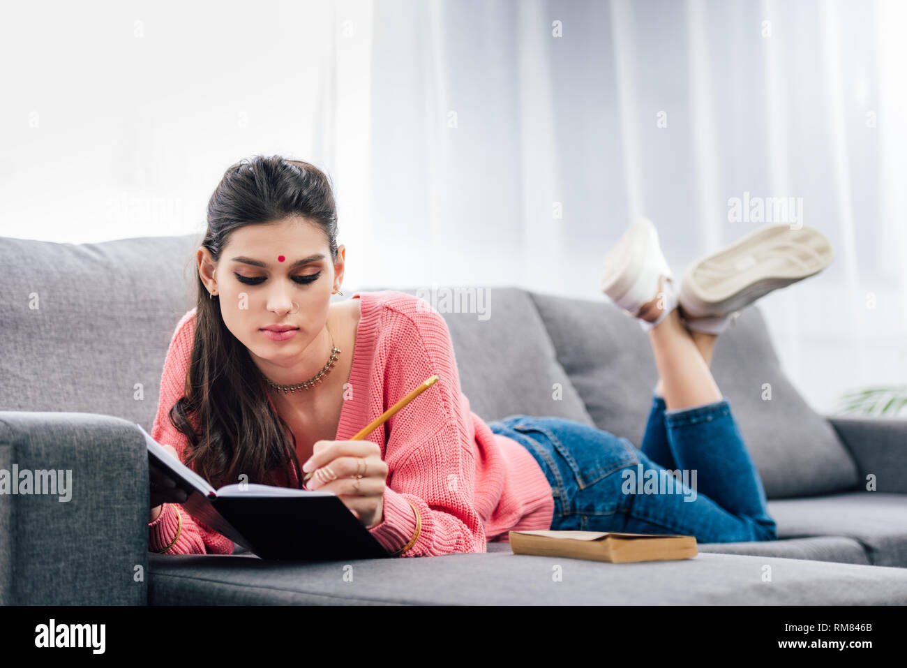 Indian girl writing in notebook hi-res stock photography and images - Alamy