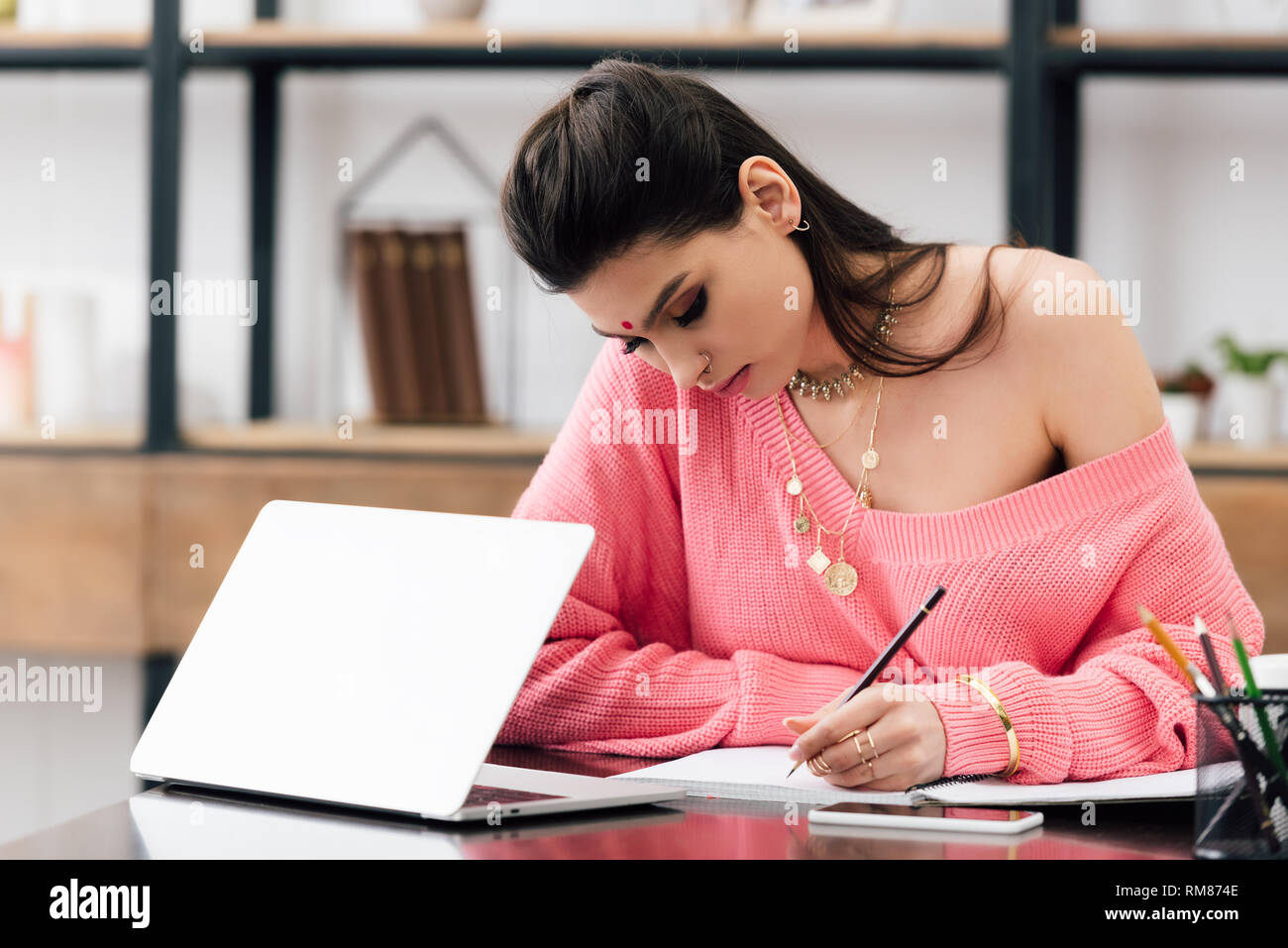 Indian girl writing in notebook hi-res stock photography and images - Alamy
