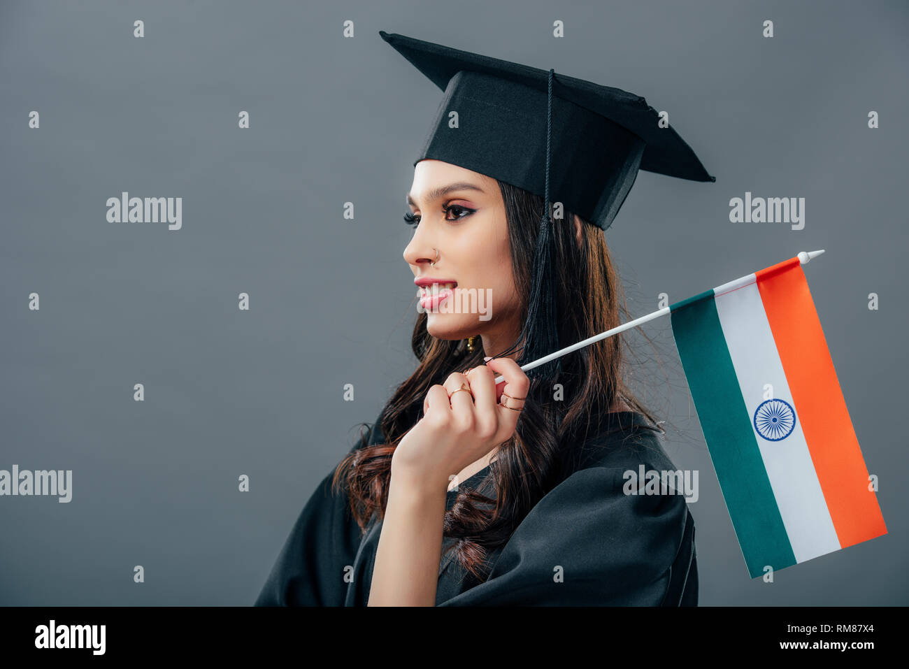 indian student in academic gown and graduation cap standing with indian ...