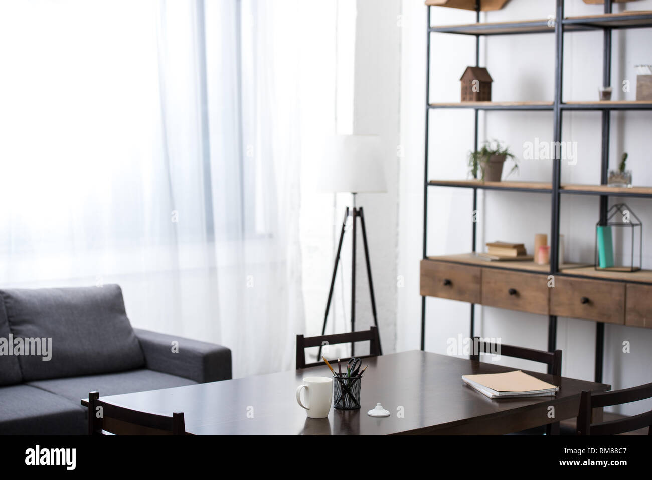 empty living room with table, sofa, lamp and shelves Stock Photo - Alamy
