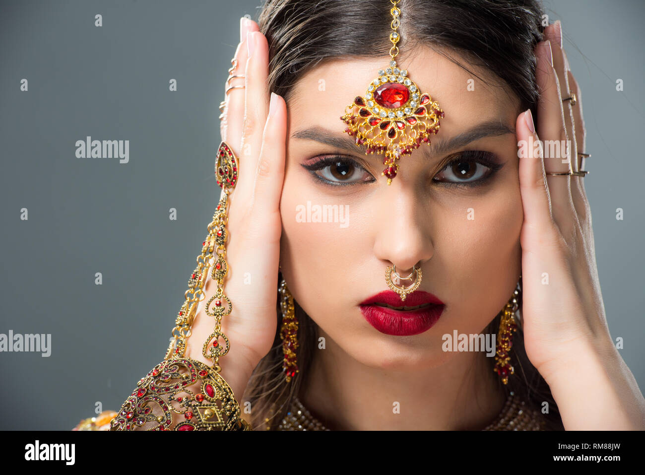 beautiful indian woman with bindi touching head, isolated on grey Stock ...