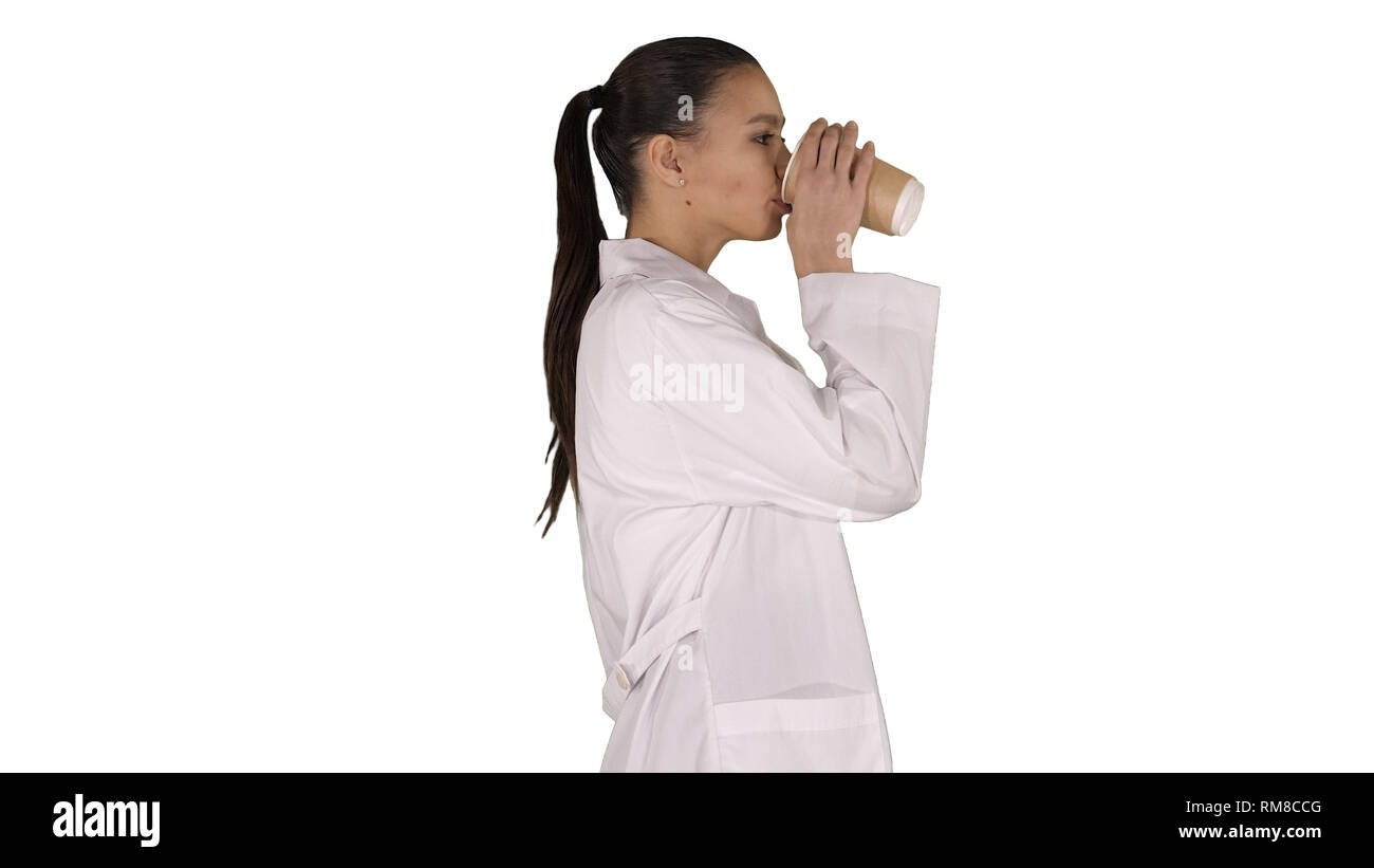 Female doctor drinking coffee and walking on white background Stock ...