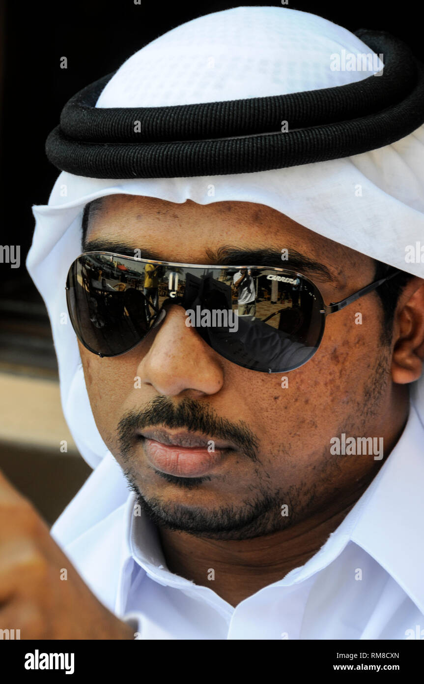 An Emirati man in traditional Arab robes and a plain white keffiyeh ...