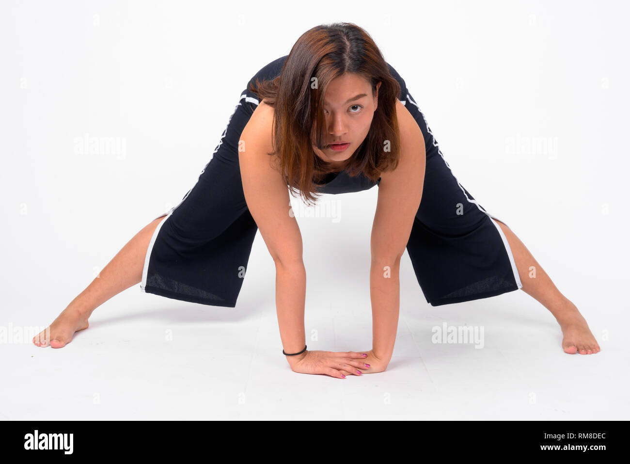 Full body shot of young beautiful Asian woman doing split Stock Photo ...