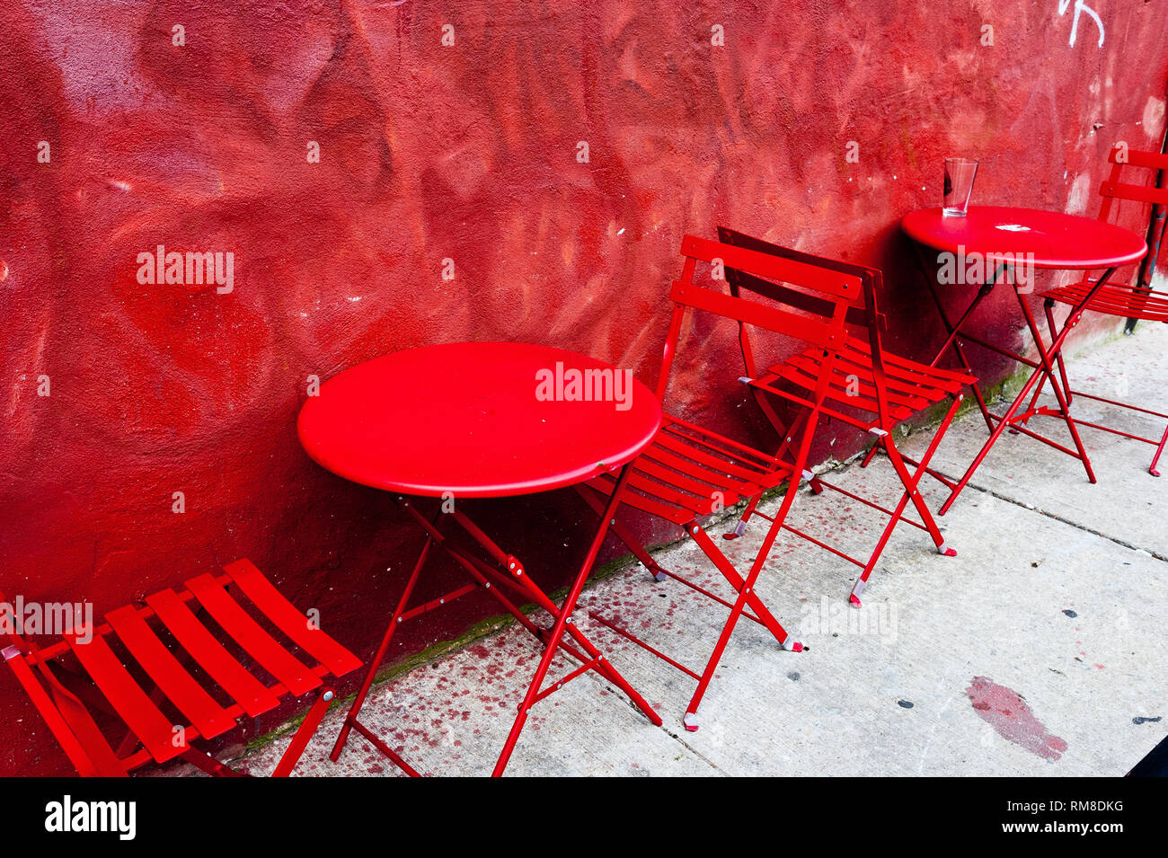 Red table and chairs outside restaurant contrasting against red wall ...