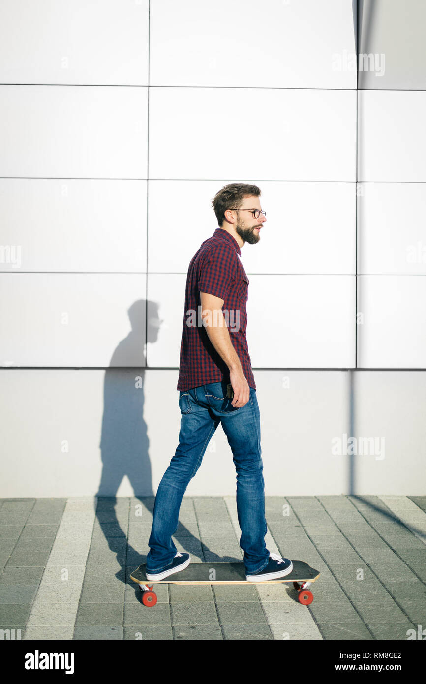 Hipster man riding longboard Stock Photo - Alamy