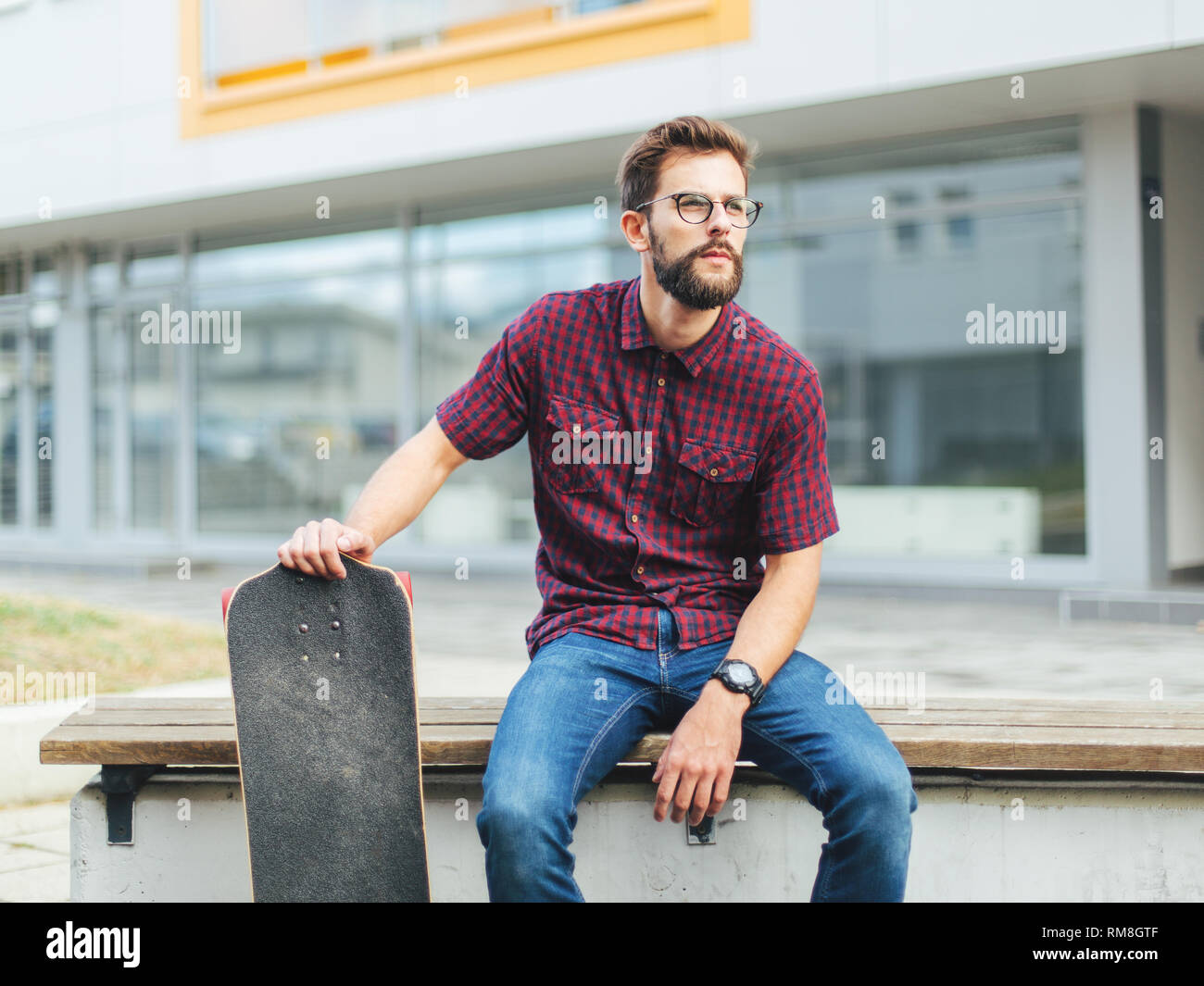 Bearded skater sitting on bench Stock Photo - Alamy