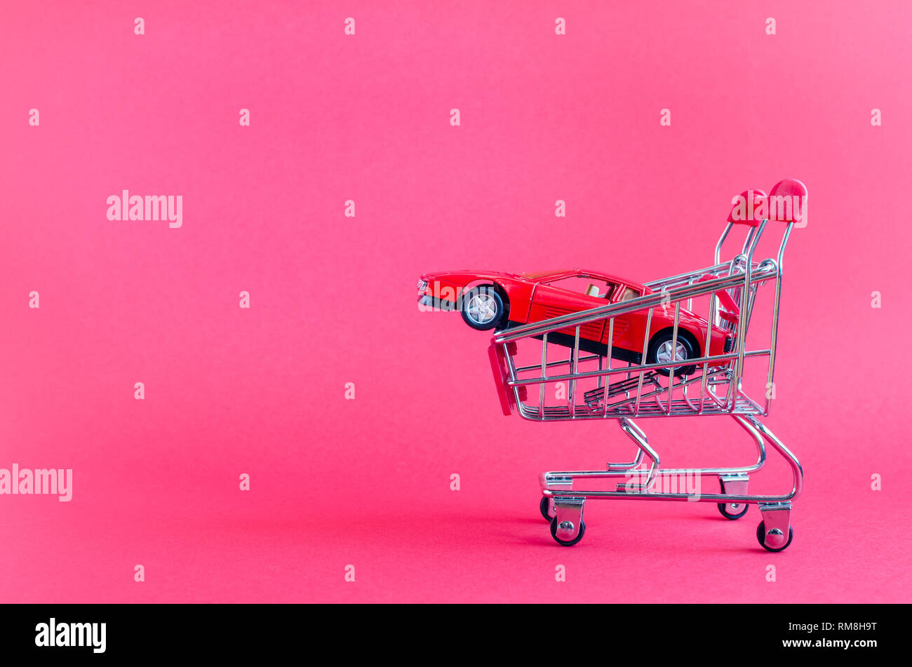 Car shopping concept. New red car in a shopping cart as a symbol for ...