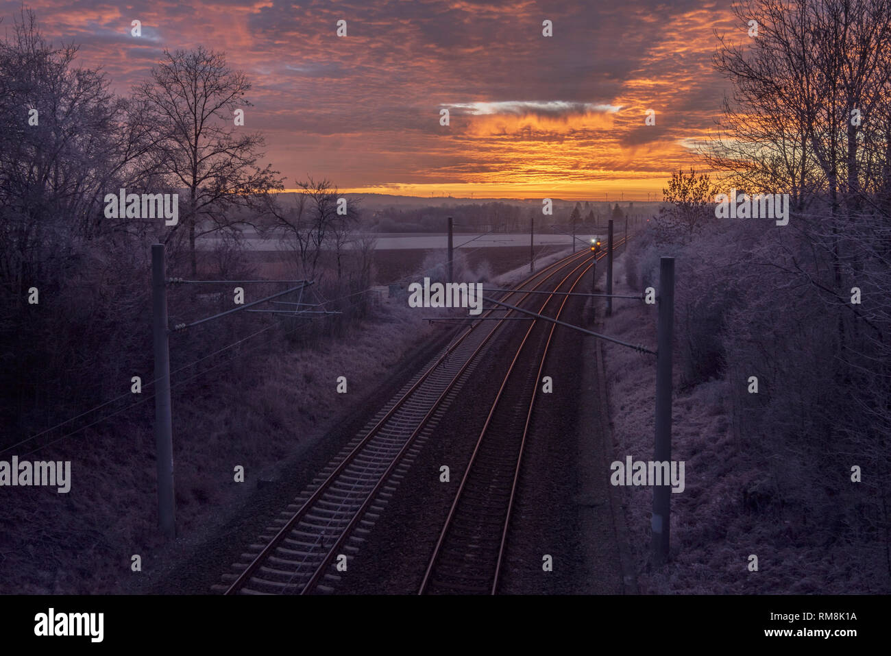 Winter sunrise and the rail tracks passing through frozen nature, near ...