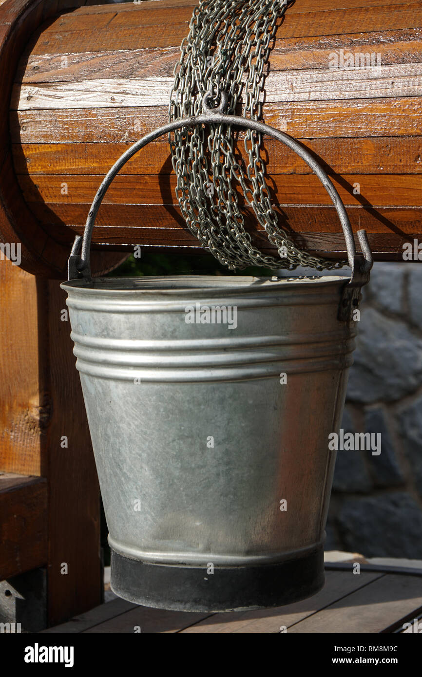 Wooden roof and a bucket of water on well Stock Photo - Alamy