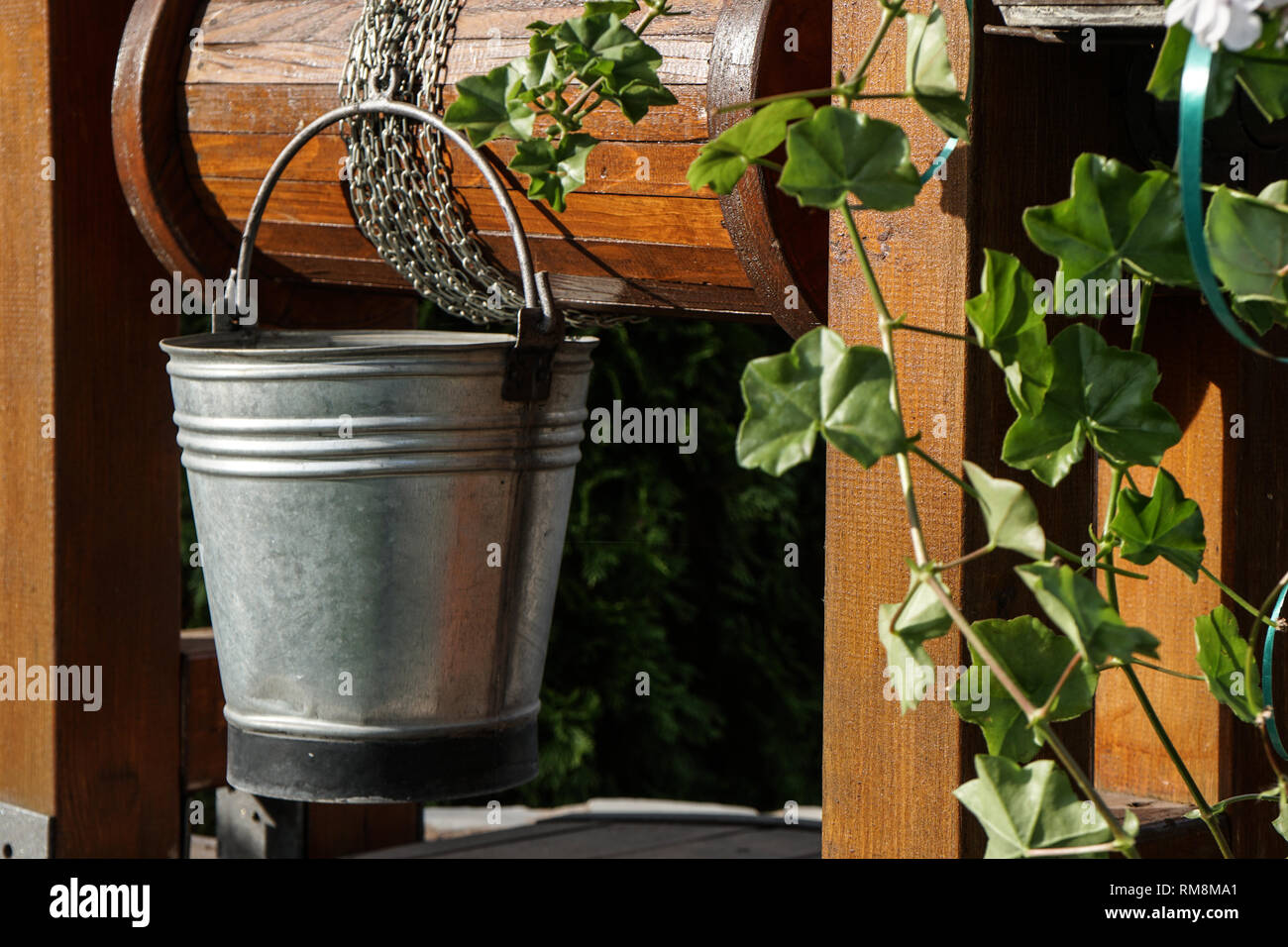 Wooden roof and a bucket of water on well Stock Photo - Alamy