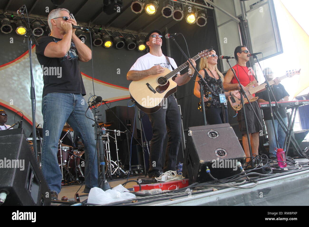 Band Together are shown performing on stage during a live concert ...