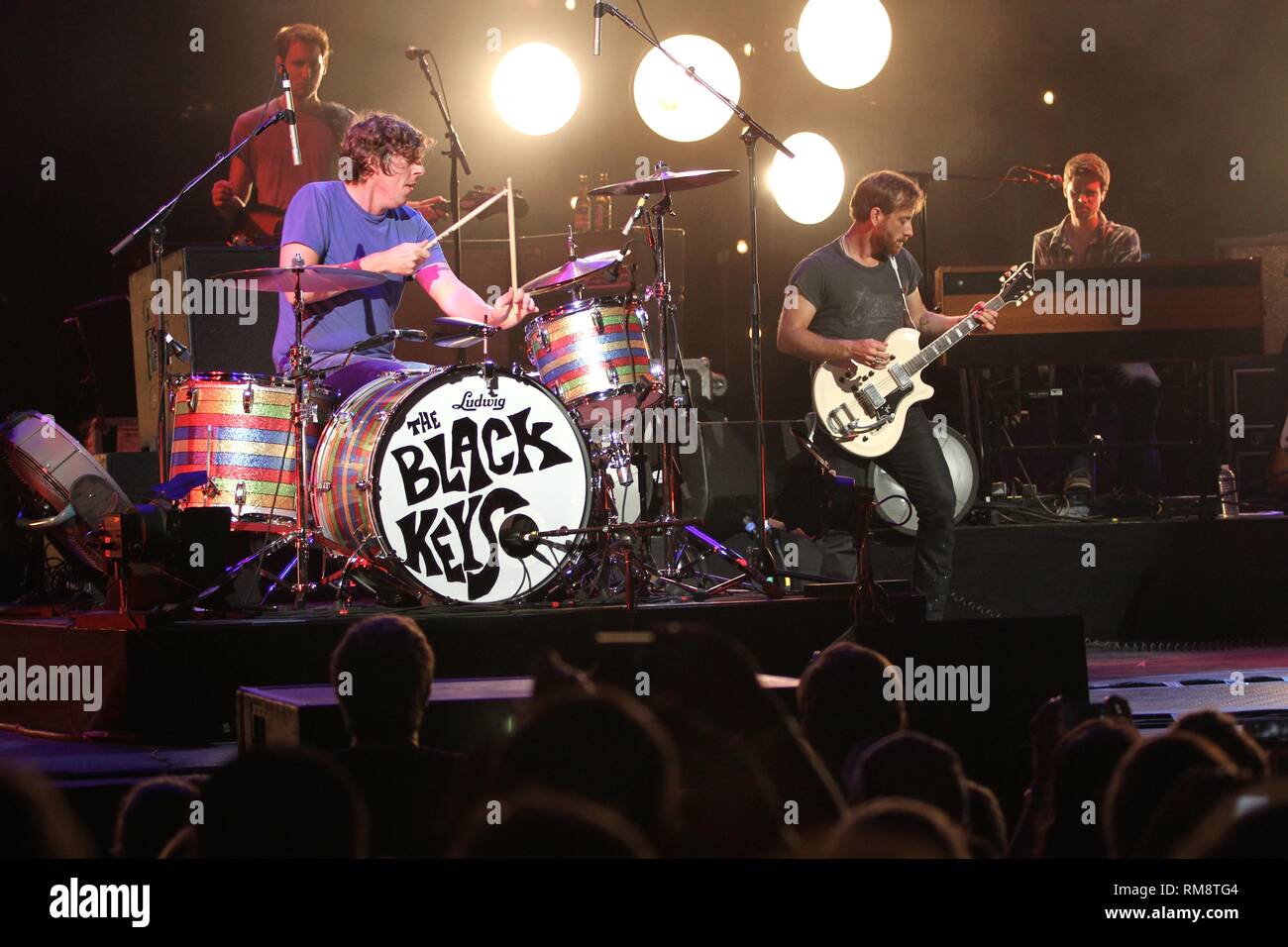 The Black Keys are shown performing on stage during a "live" concert ...
