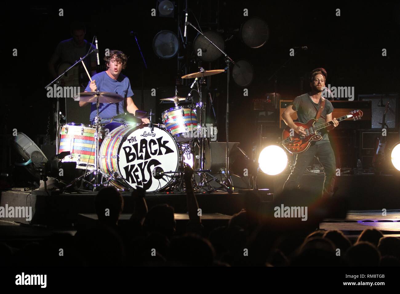 The Black Keys are shown performing on stage during a "live" concert ...