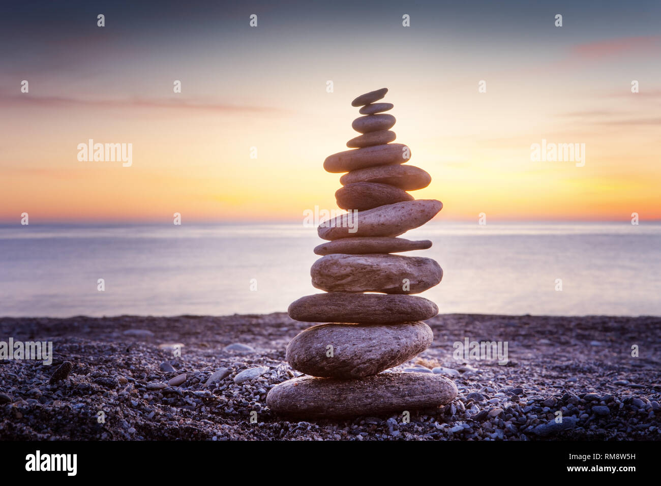 Rock balancing or stone balancin, naturally balanced on a beach with ...