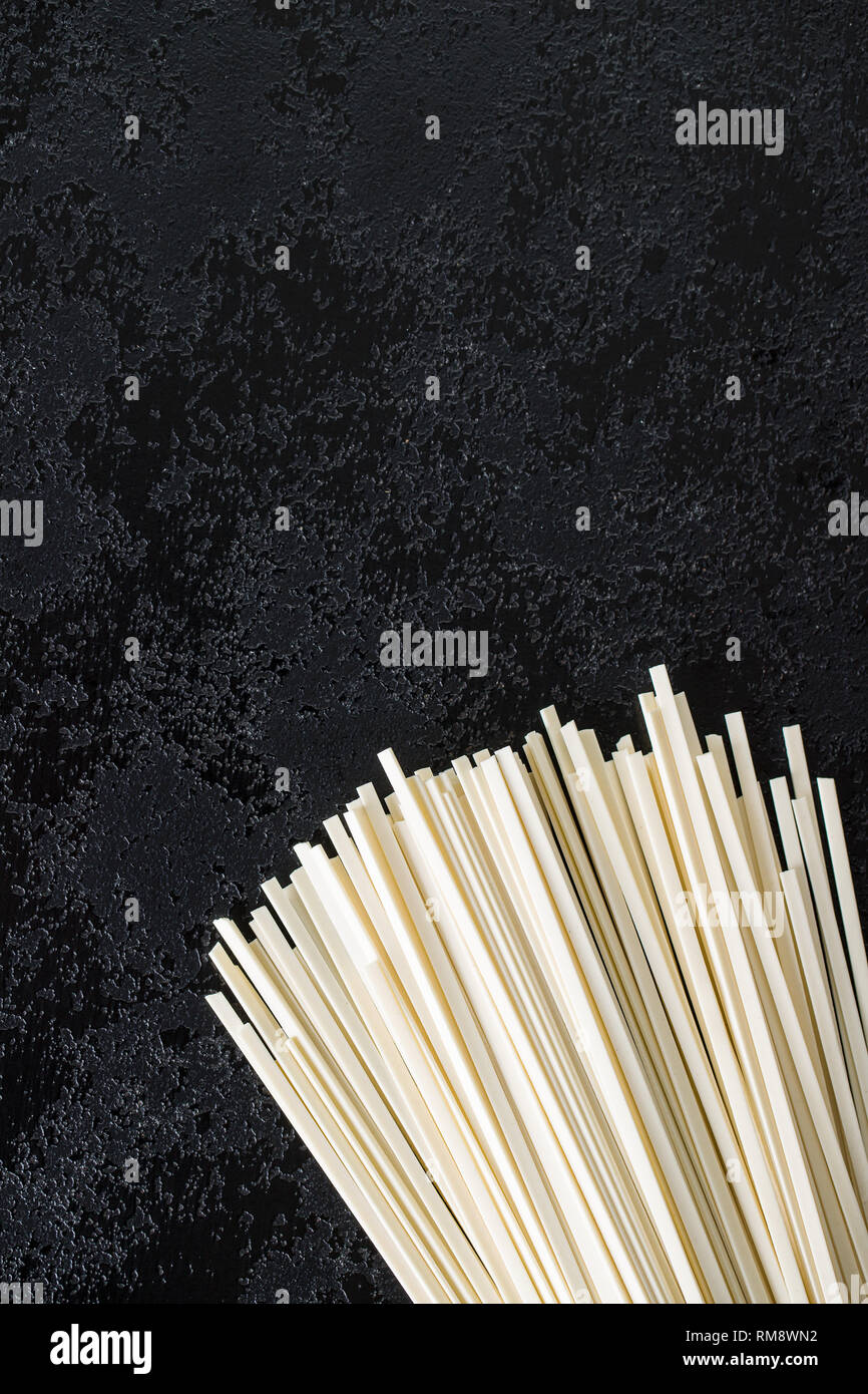 Raw udon noodles on black table. Top view Stock Photo - Alamy
