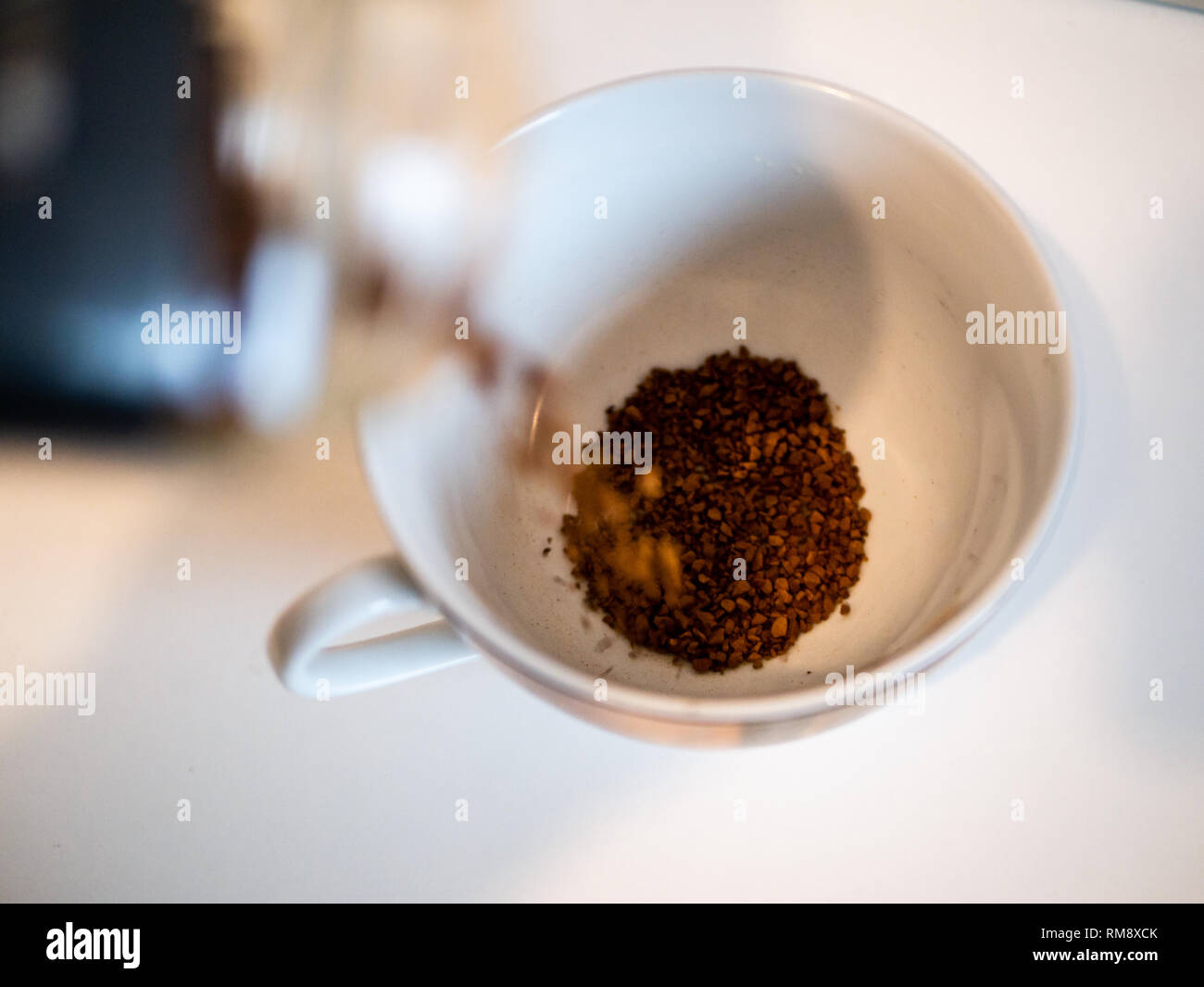 Instant coffee poweder being poured into a n empty coffee mug Stock ...