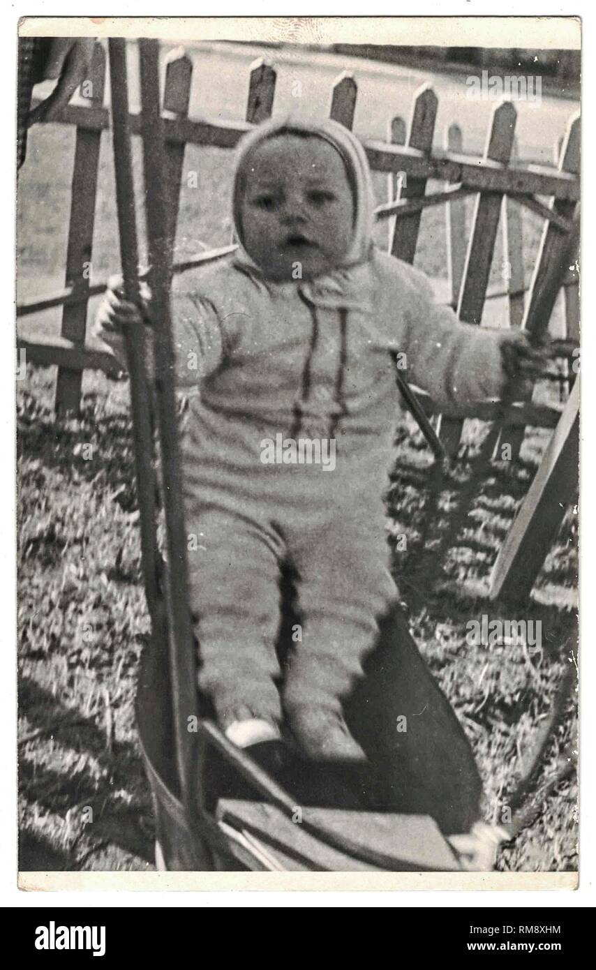 Retro photo shows toddler playing at playground. Child rocking on the ...