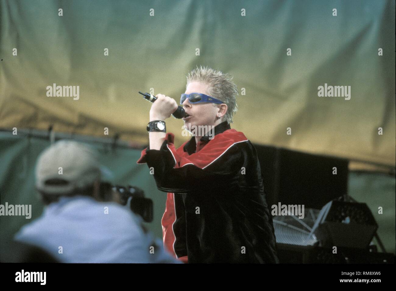 The lead singer of the Offspring is shown performing on stage during ...