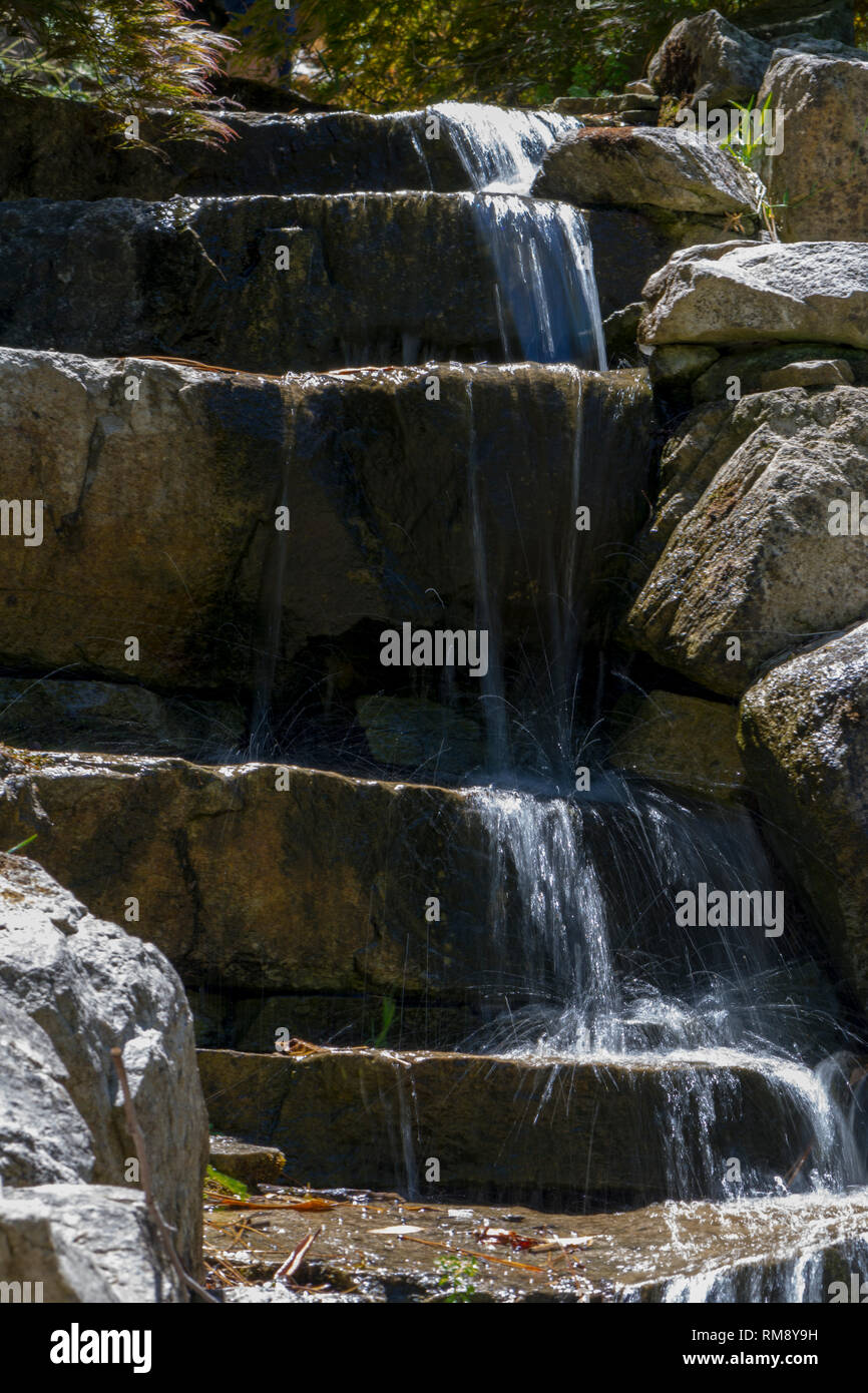 Flowing water over a rock feature waterfall Stock Photo - Alamy