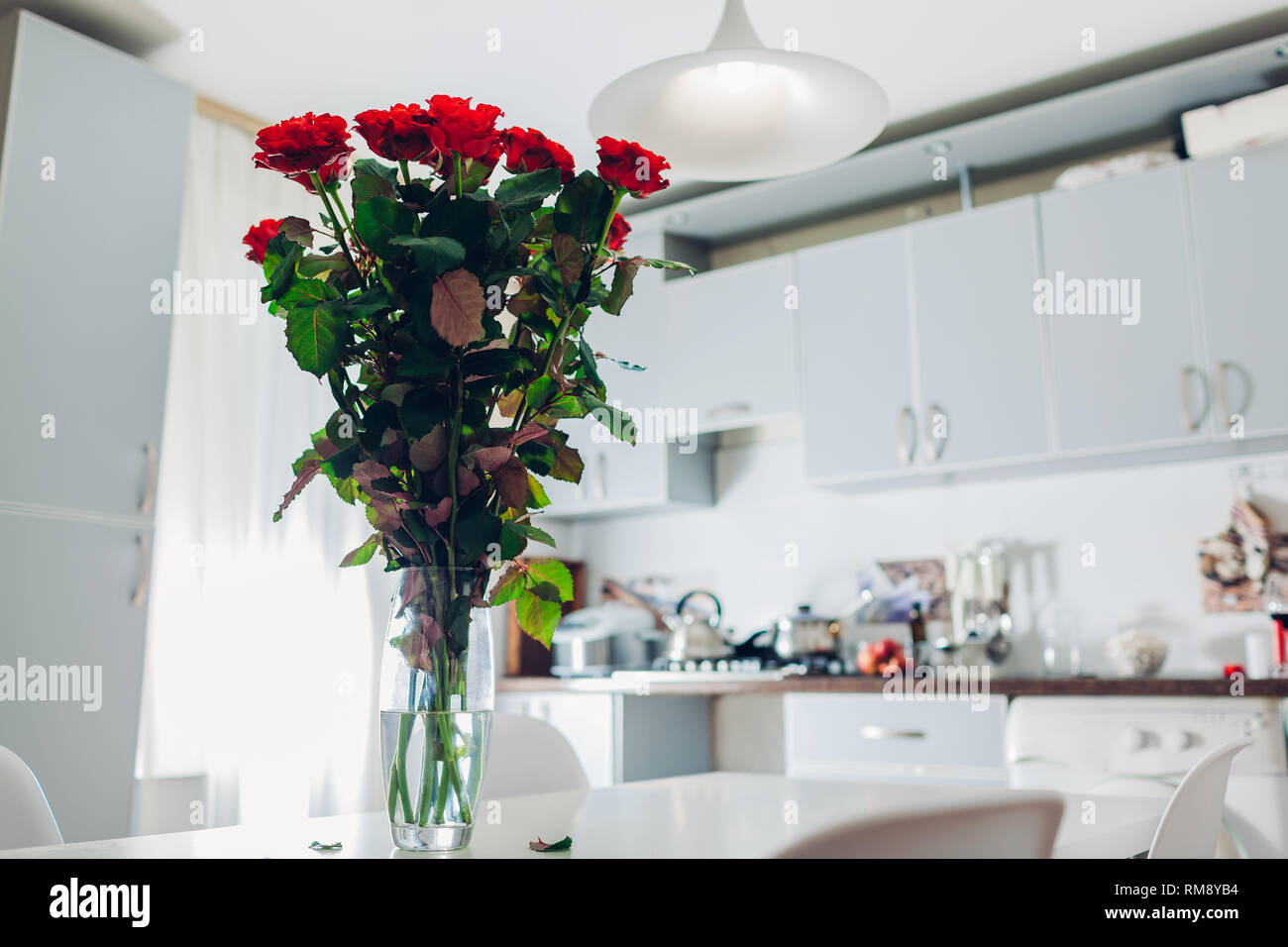 Bouquet of red roses left on kitchen. Surprise for woman. Valentine's ...
