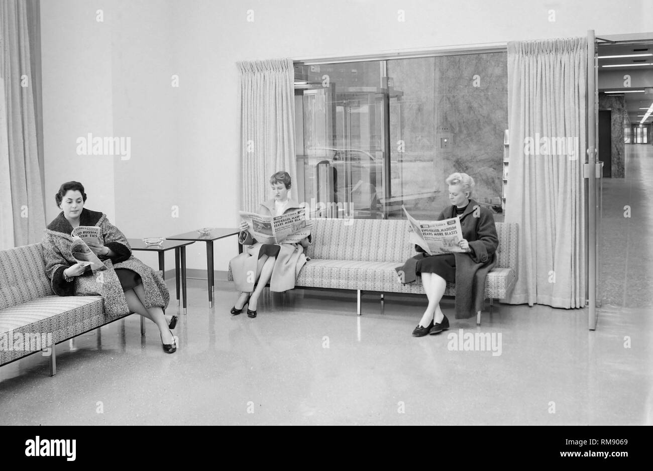 Three women read their Chicago Sun Times newspapers in the lobby of an ...