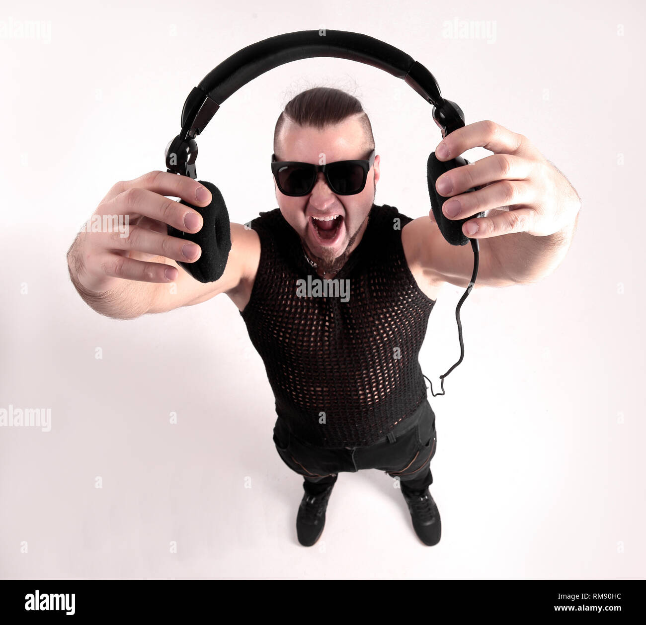 close up.cool male rapper looks at the camera and shows the headphones ...