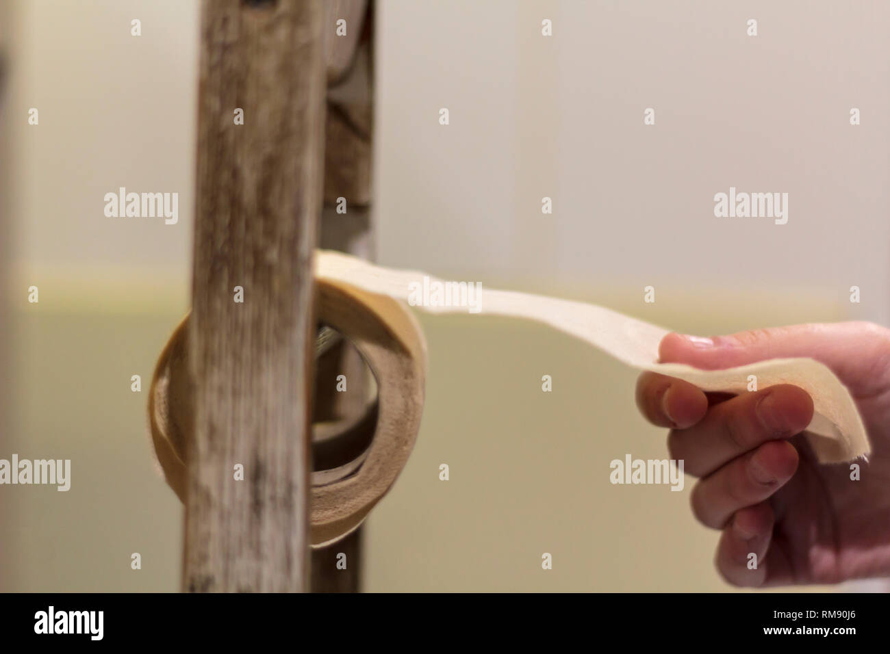 Hand taking toilet paper from roll holder Stock Photo - Alamy