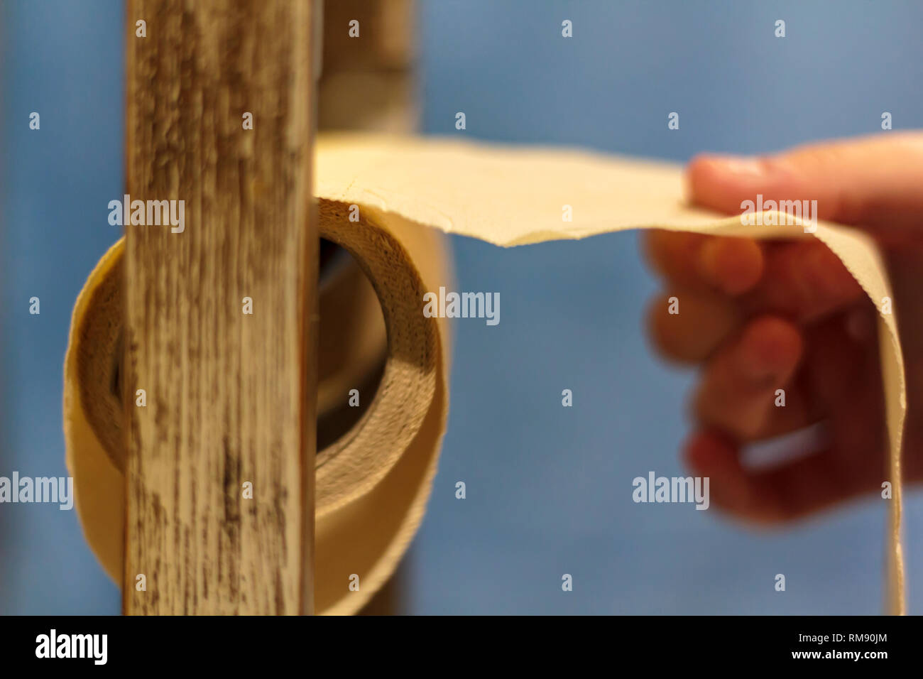 Hand pulling toilet paper Stock Photo - Alamy