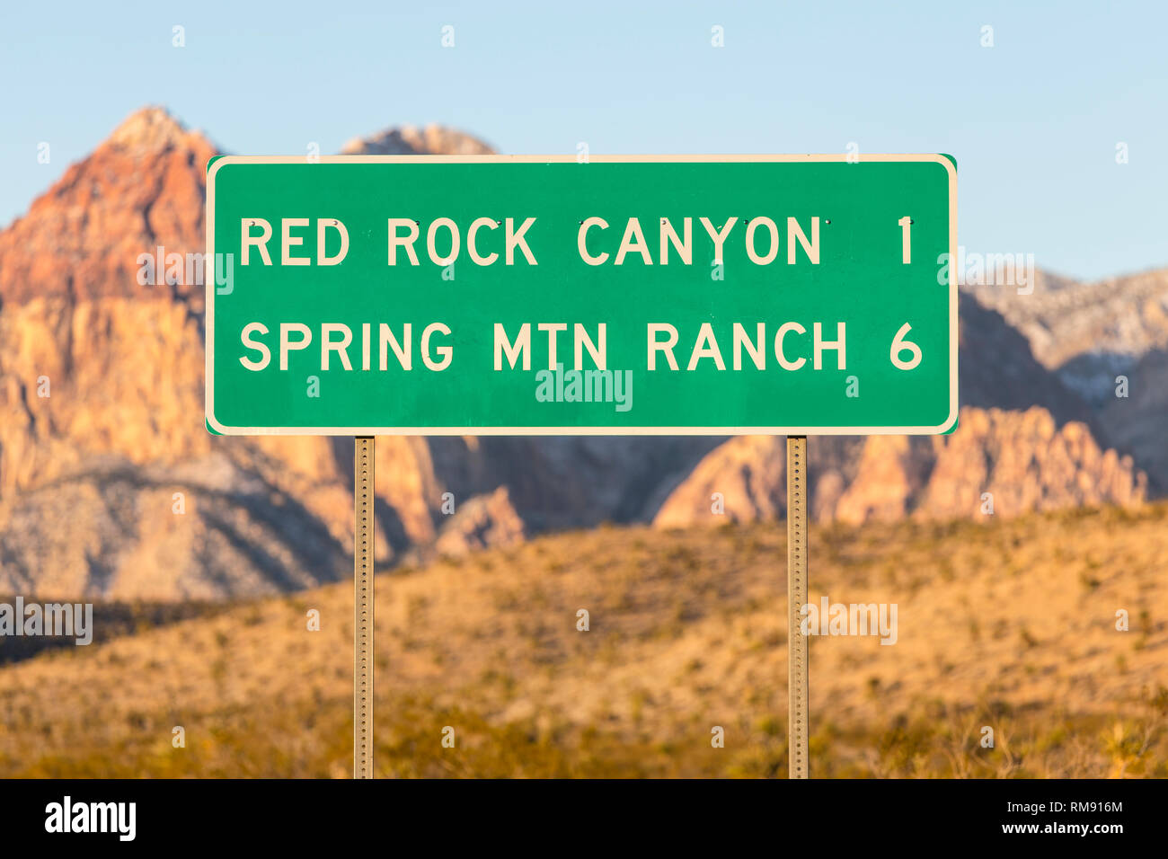 Early morning view of route 159 highway sign and desert peaks near Red ...