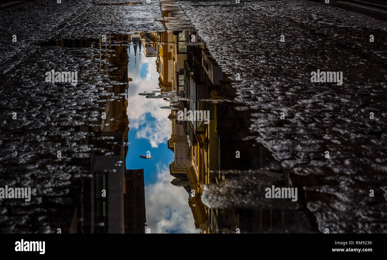 Reflection of the city in a puddle on the asphalt. Reflection of the ...