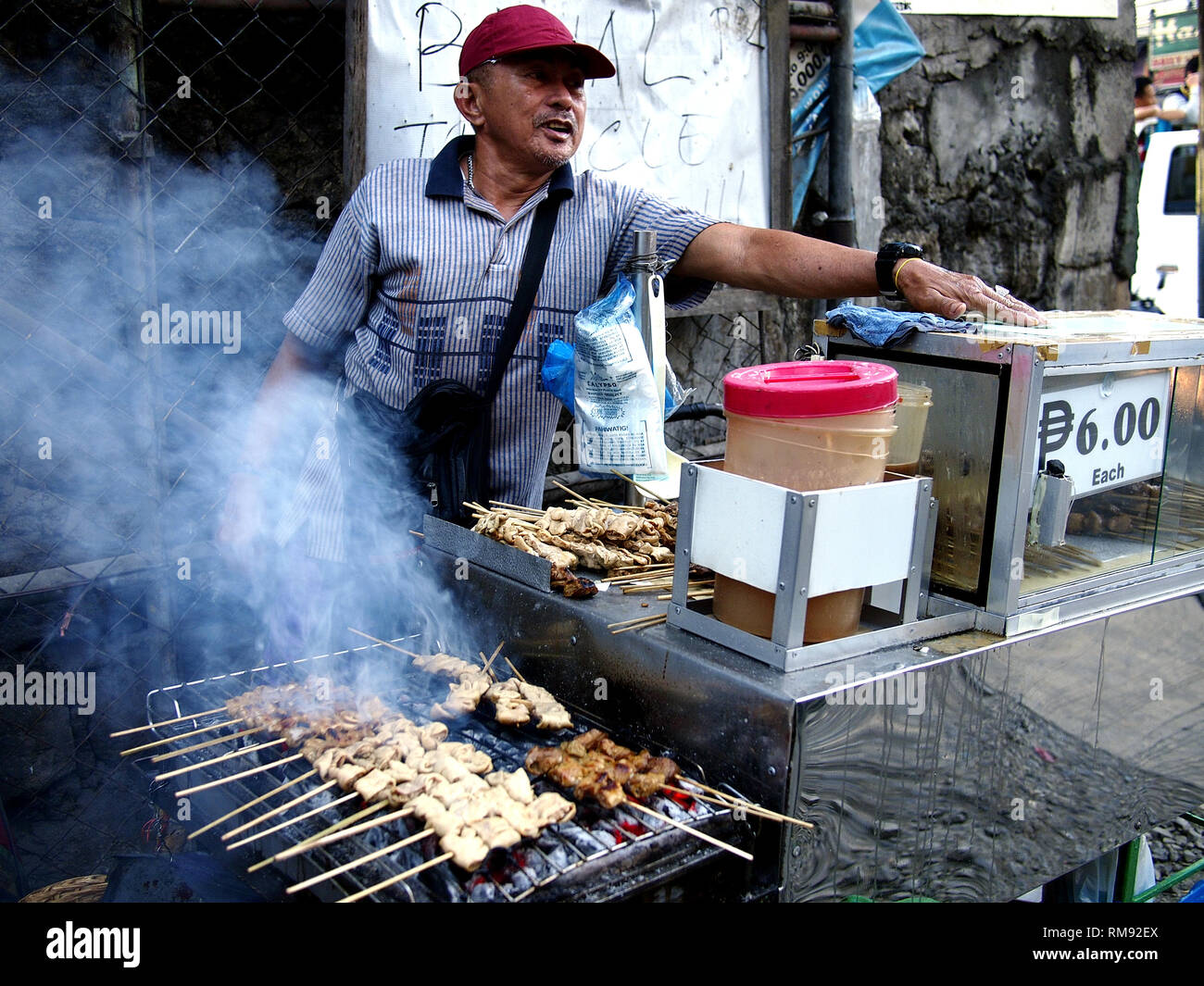 ANTIPOLO CITY, PHILIPPINES - JANUARY 26, 2019: Street vendors grill and ...