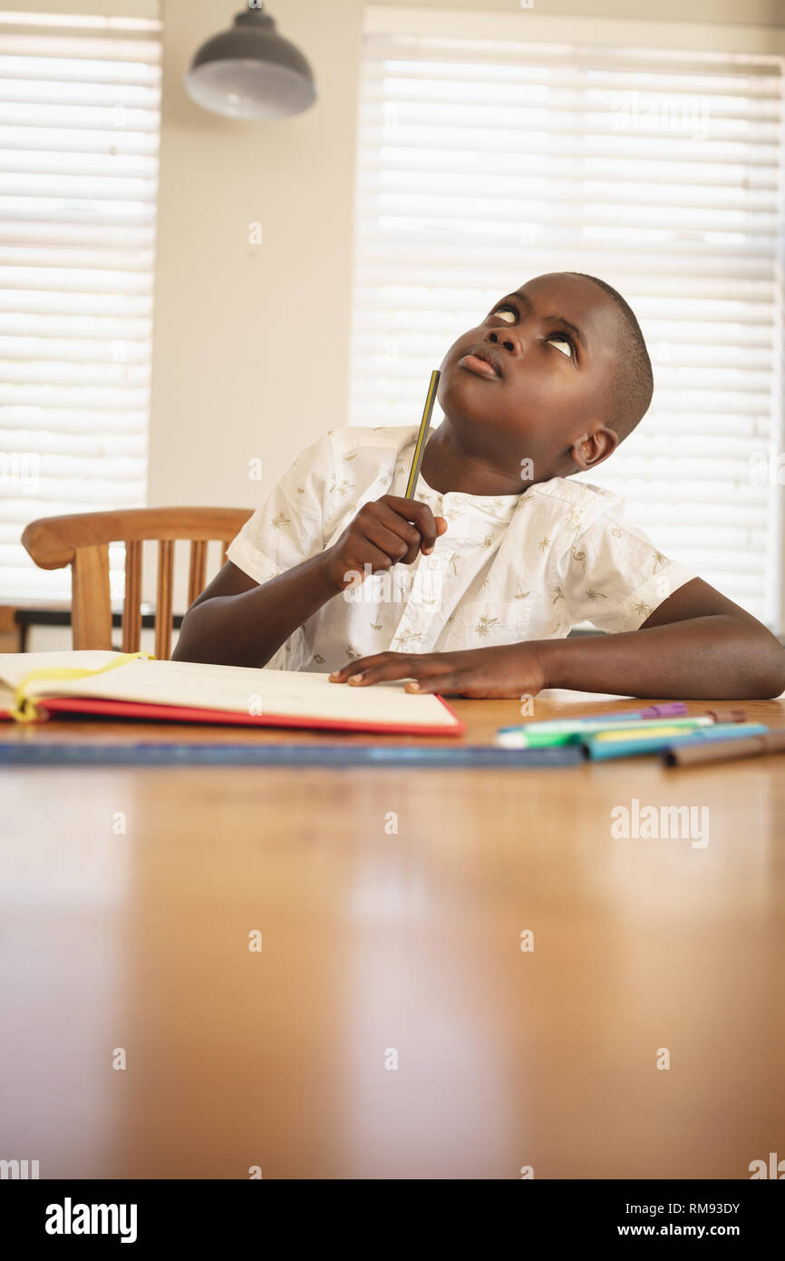 African American boy doing homework on dining table in kitchen Stock ...