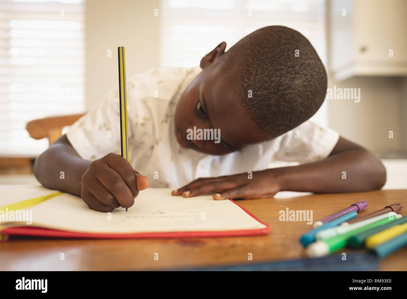 African American boy doing homework on dining table in kitchen Stock ...