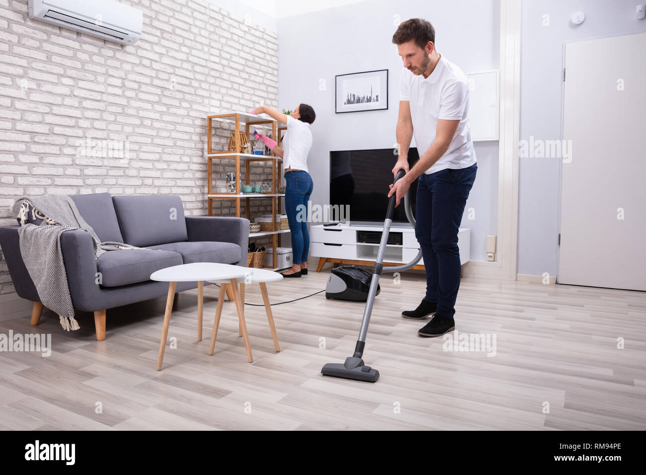 Side View Of Two Persons Cleaning The Shelf And Mopping Floor In The ...