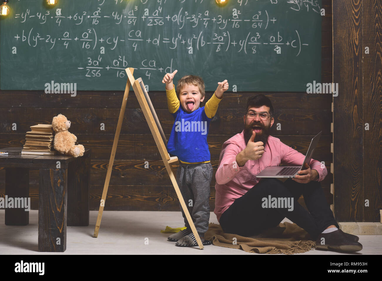 Old books on a round wooden table. Home tutor helping boy with studies ...