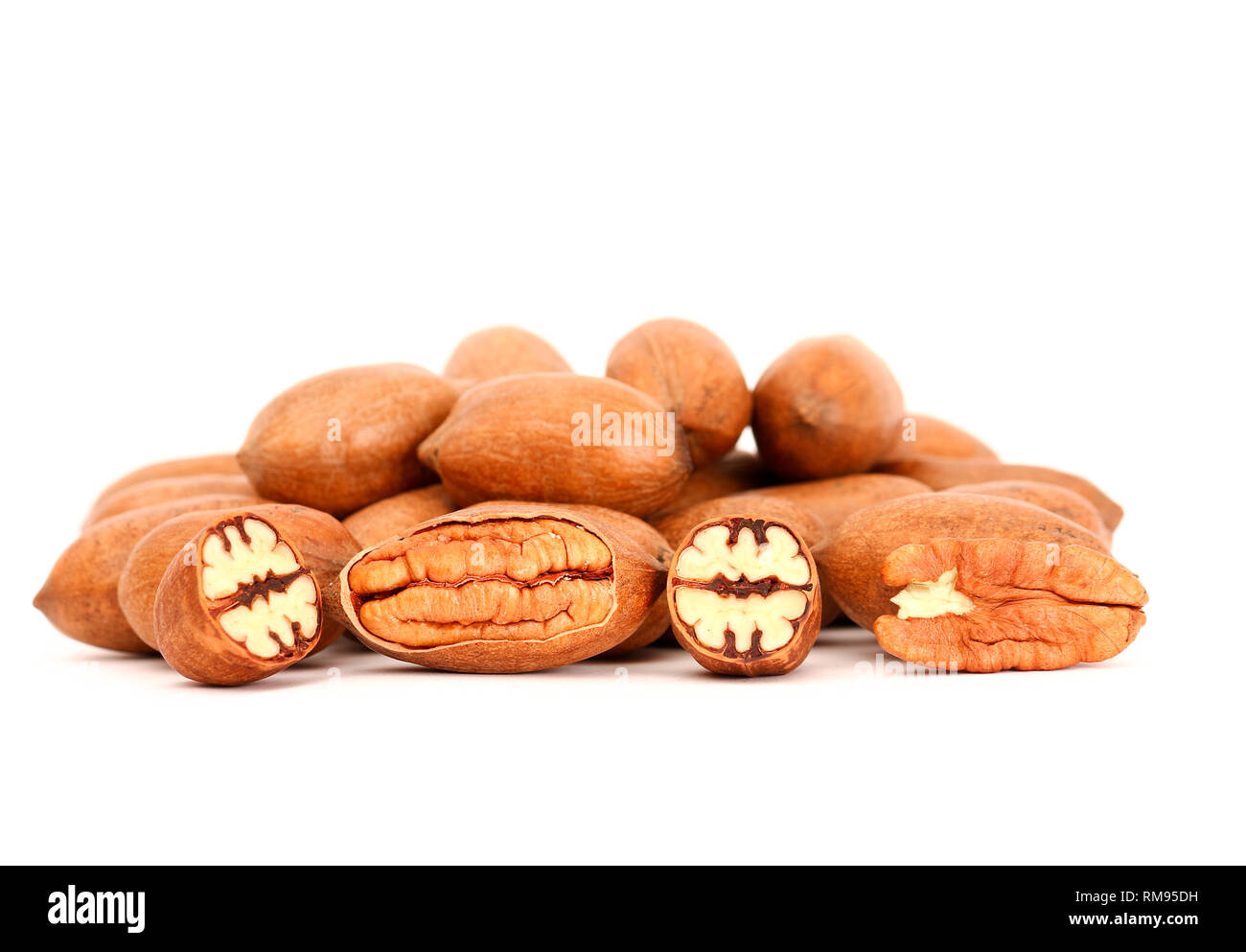 A pile of pecan nuts with details on the section of the fruit and the ...