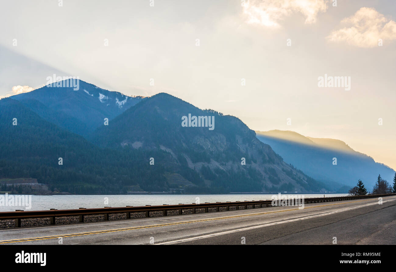 Road with separation marking go along the river with high mountains on ...