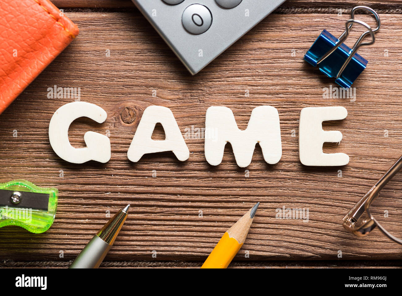 Game word on wooden table and office stationary around Stock Photo - Alamy
