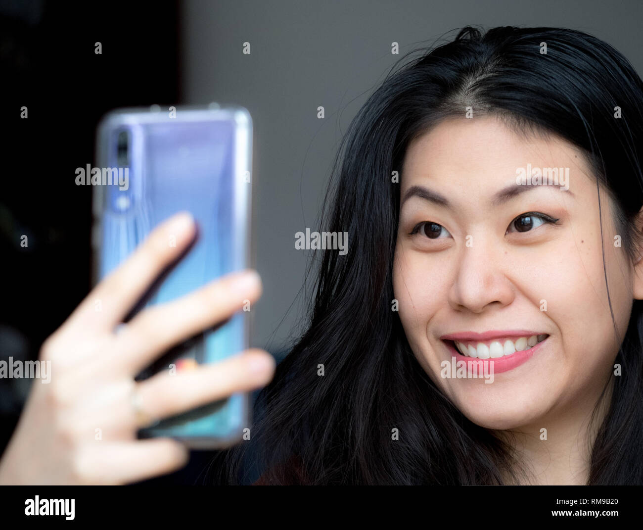 Asian young beautiful cheerful woman smiling, waving and saying hi to ...