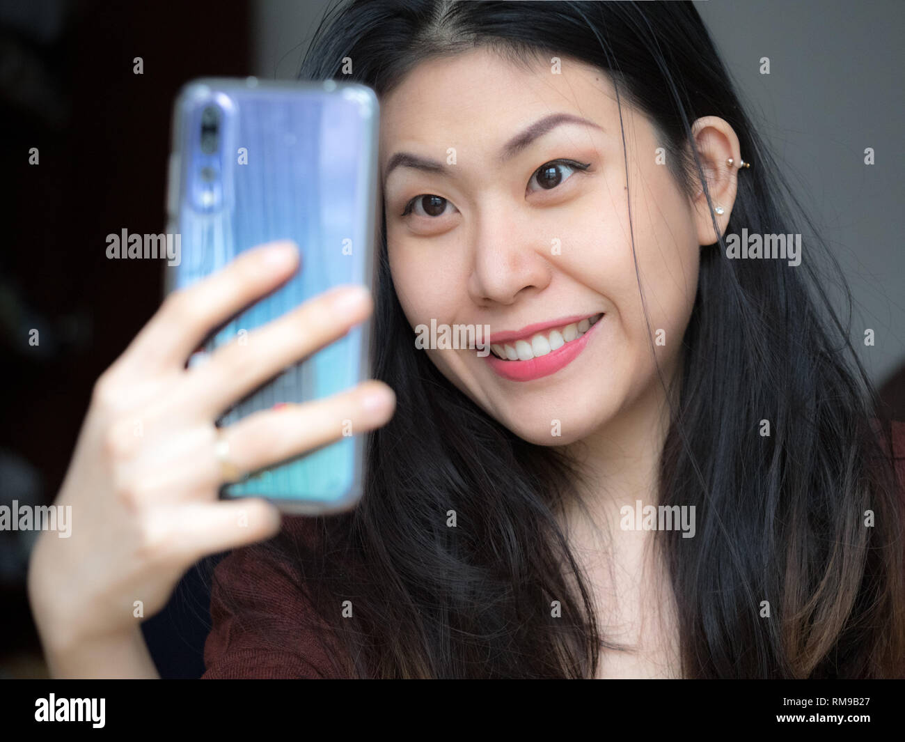 Asian young beautiful cheerful woman smiling, waving and saying hi to ...