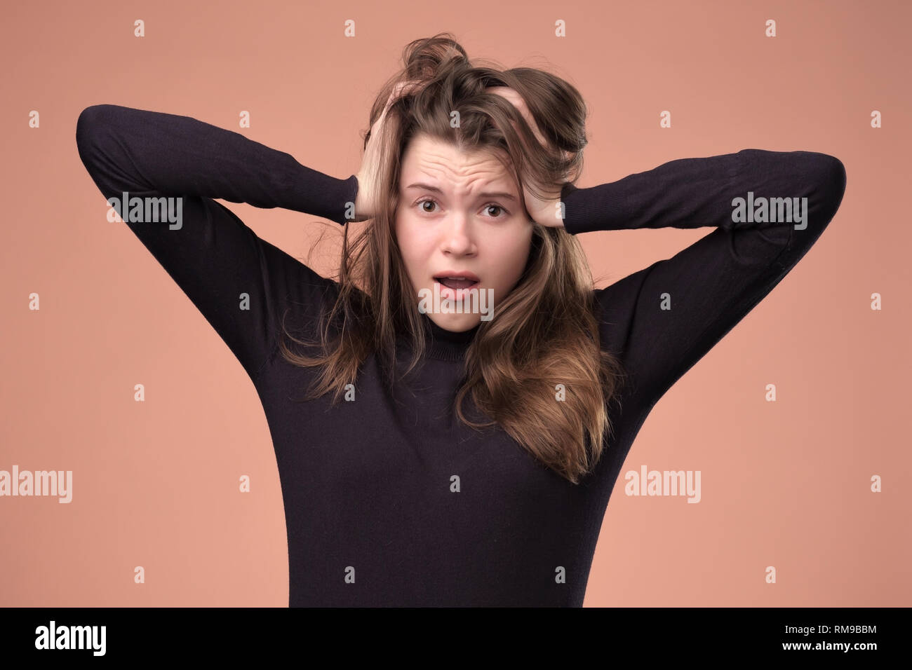 Pretty girl screaming in panic on brown baclground Stock Photo - Alamy