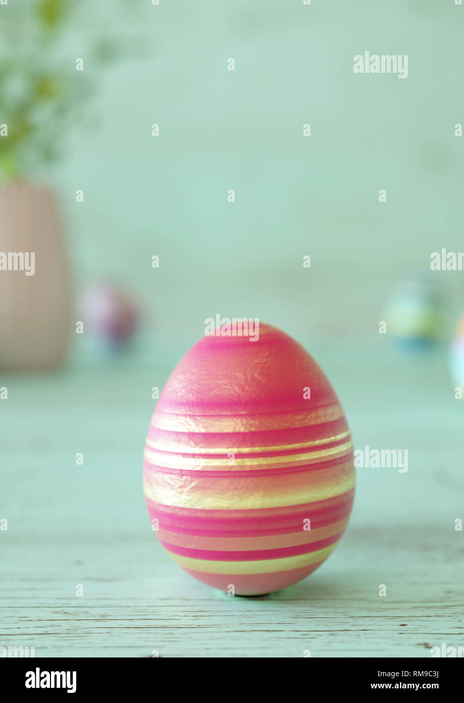 Easter egg standing on its blunt end, decorated in red with golden ...