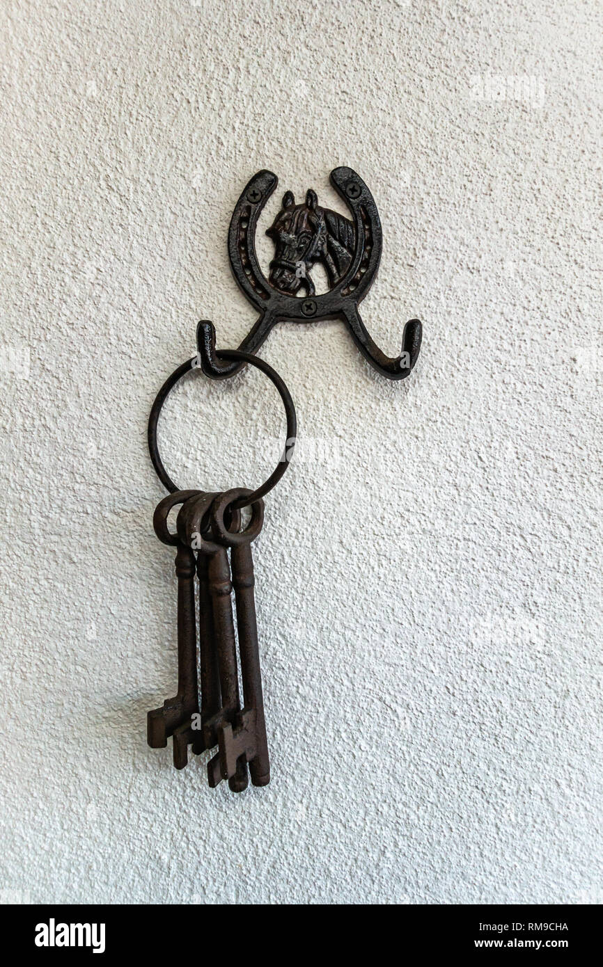 Large Old iron metal keys hanging on a hook on a plain white wall Stock ...