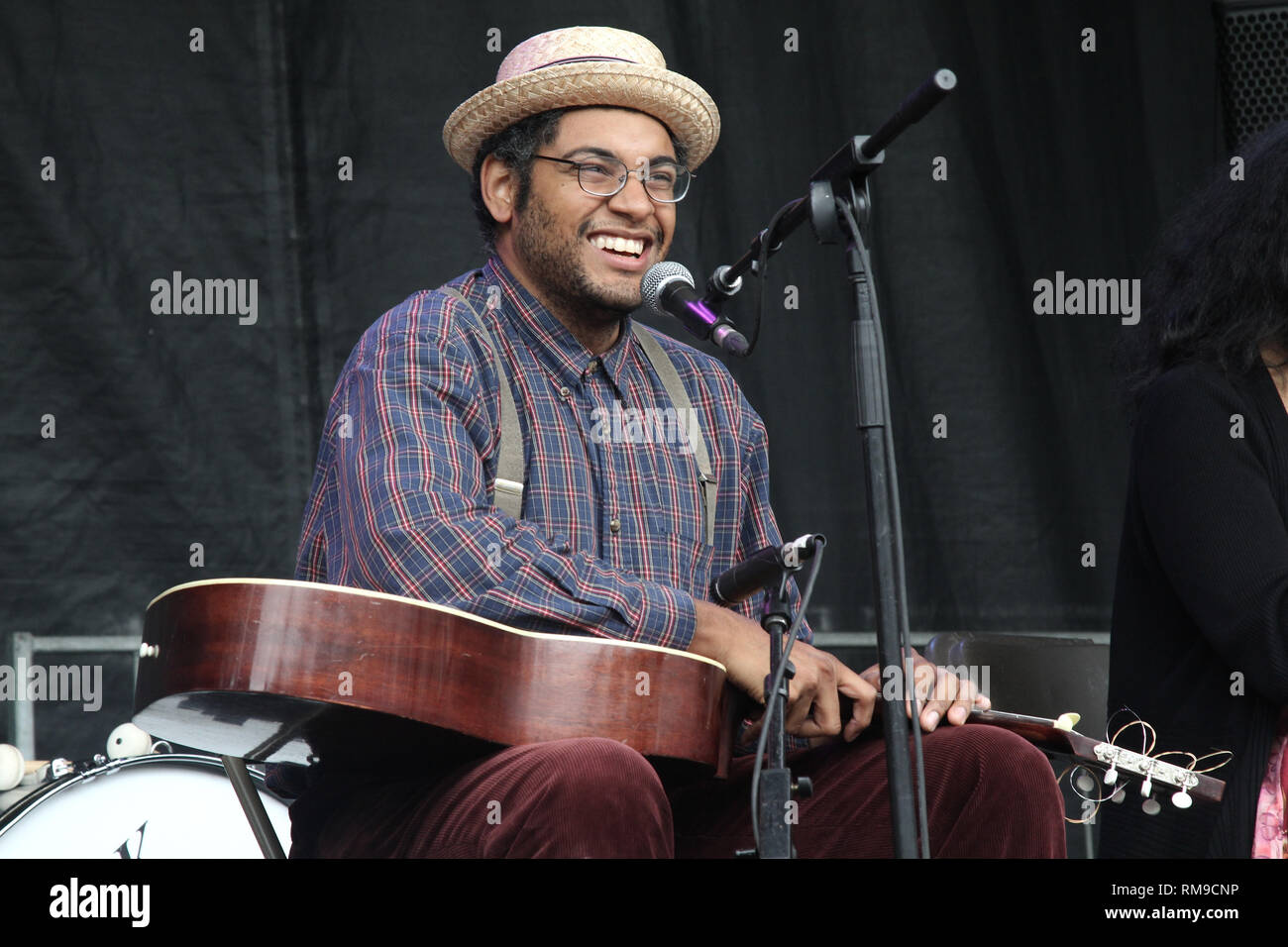 Musician Dom Flemons is shown performing on stage during a "live ...